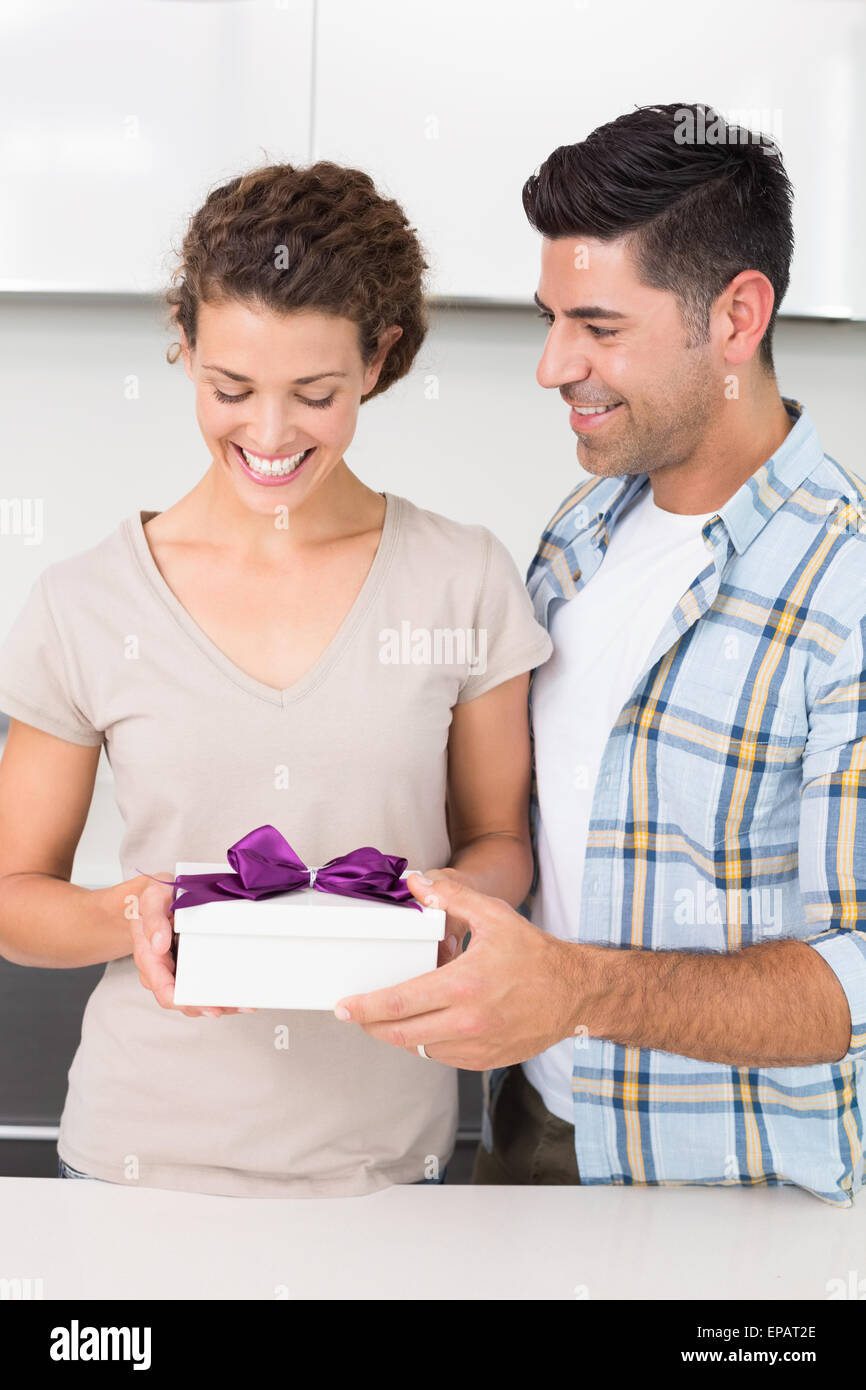 Cheerful woman holding a gift from her partner Stock Photo - Alamy