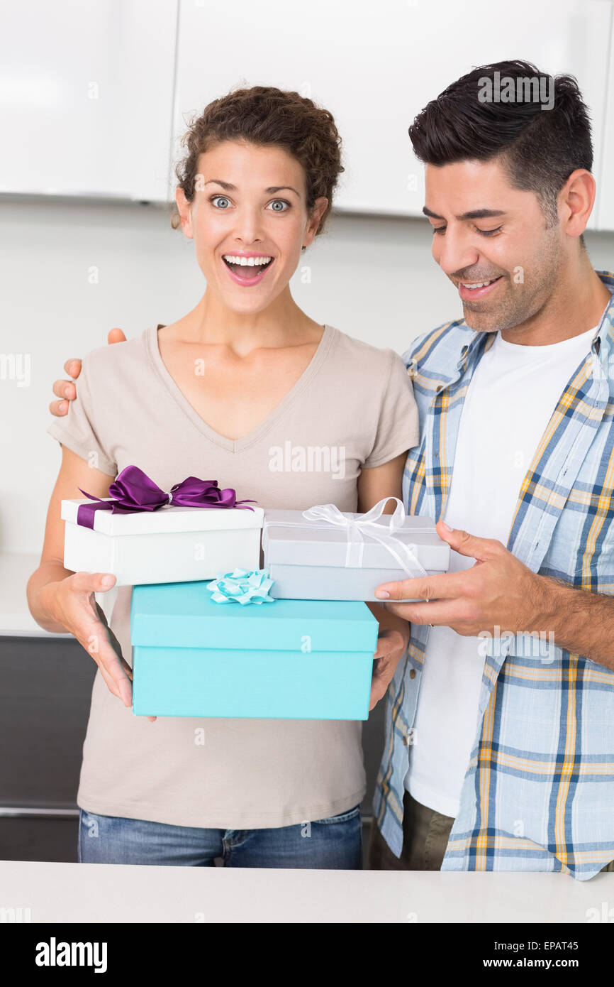 Shocked woman holding many gifts from her partner Stock Photo - Alamy