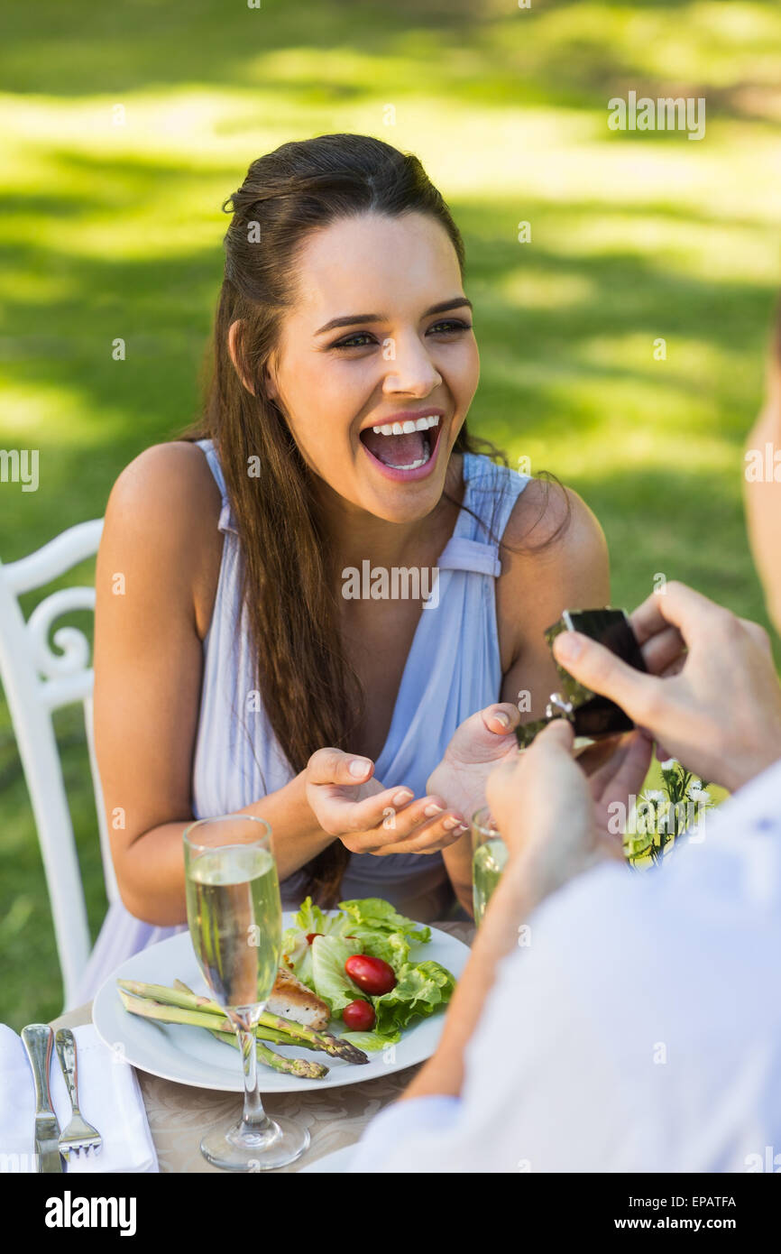 Man proposing cheerful woman at an outdoor café Stock Photo - Alamy