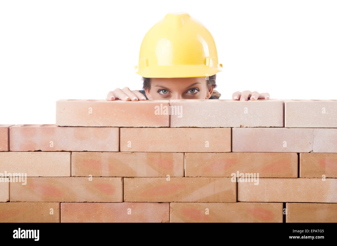 Young female builder near brick wall Stock Photo - Alamy