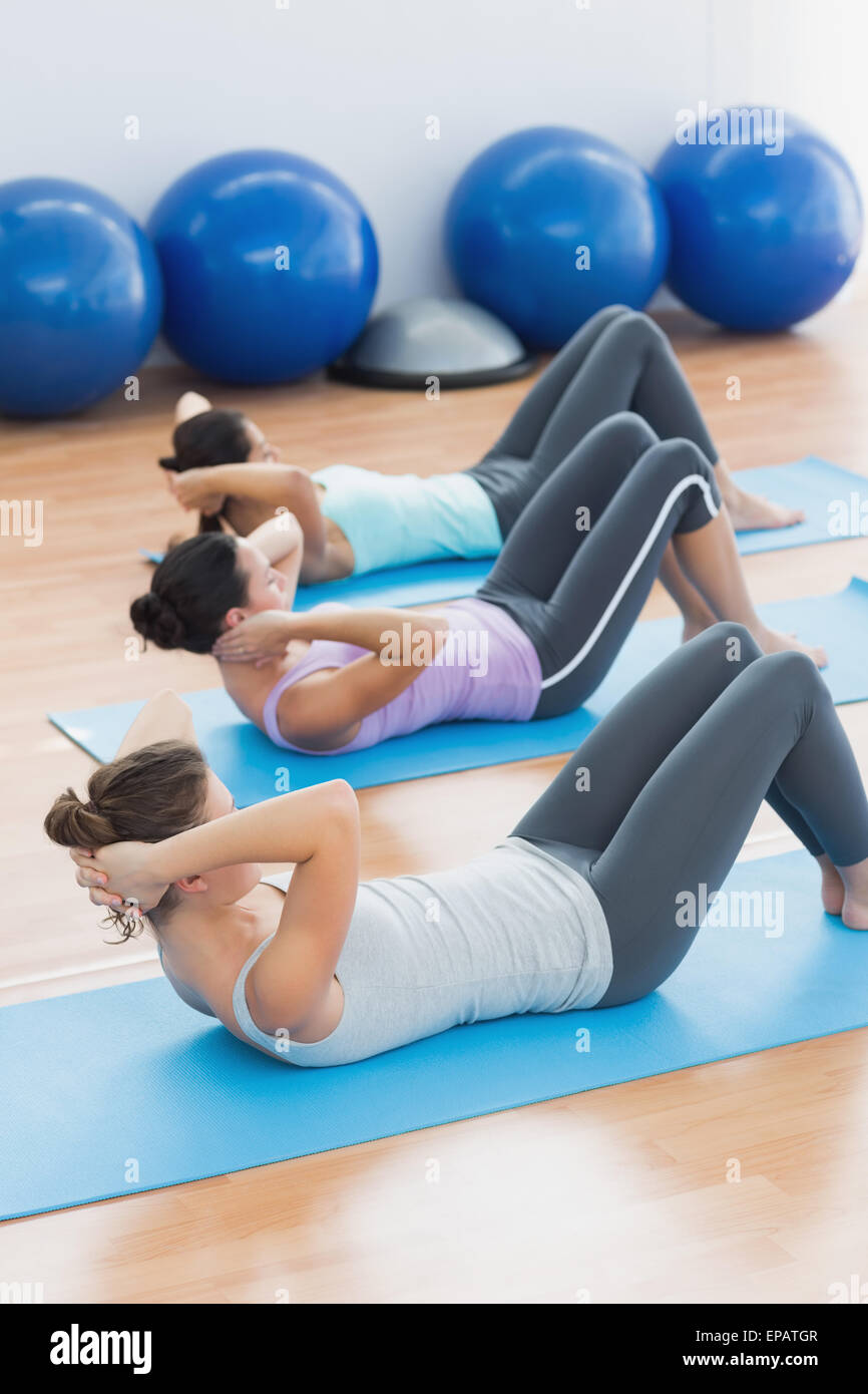 Determined women doing sit ups at fitness studio Stock Photo - Alamy
