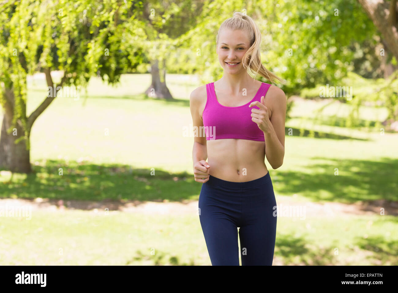 Healthy and beautiful woman in sports bra jogging in park Stock Photo ...