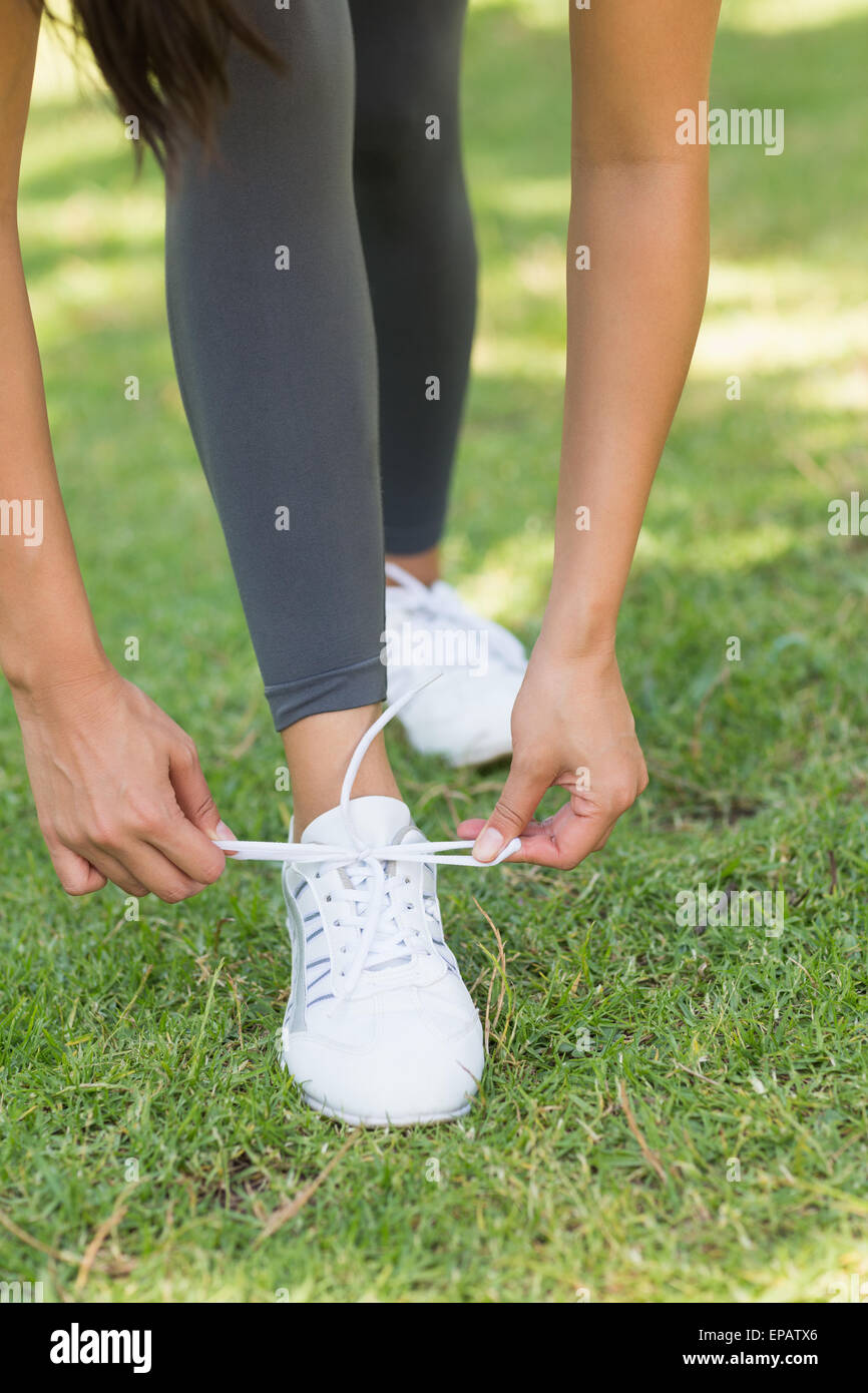Low section of woman tying shoe lace at park Stock Photo - Alamy