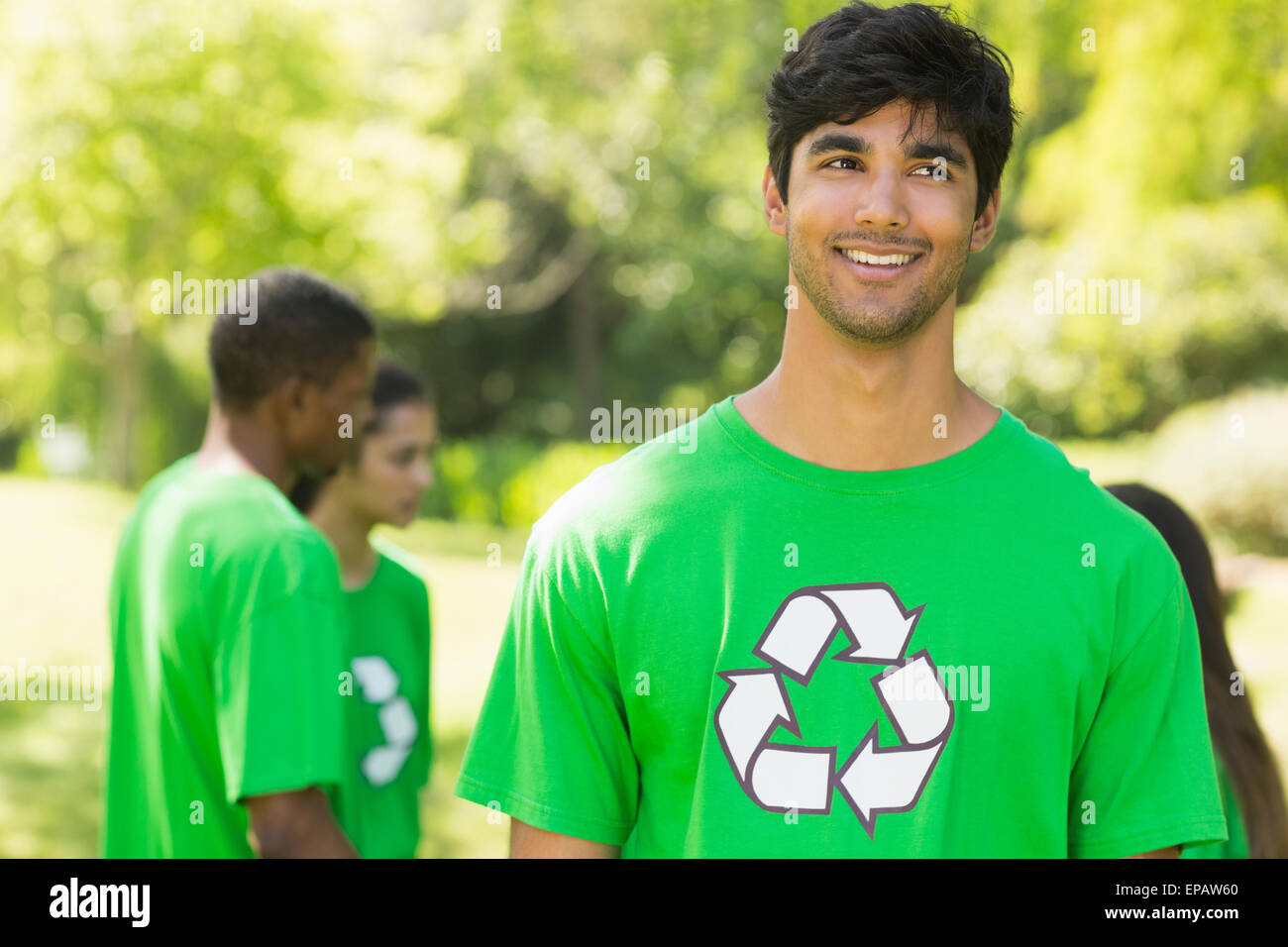 Smiling man wearing green recycling t-shirt in park Stock Photo - Alamy