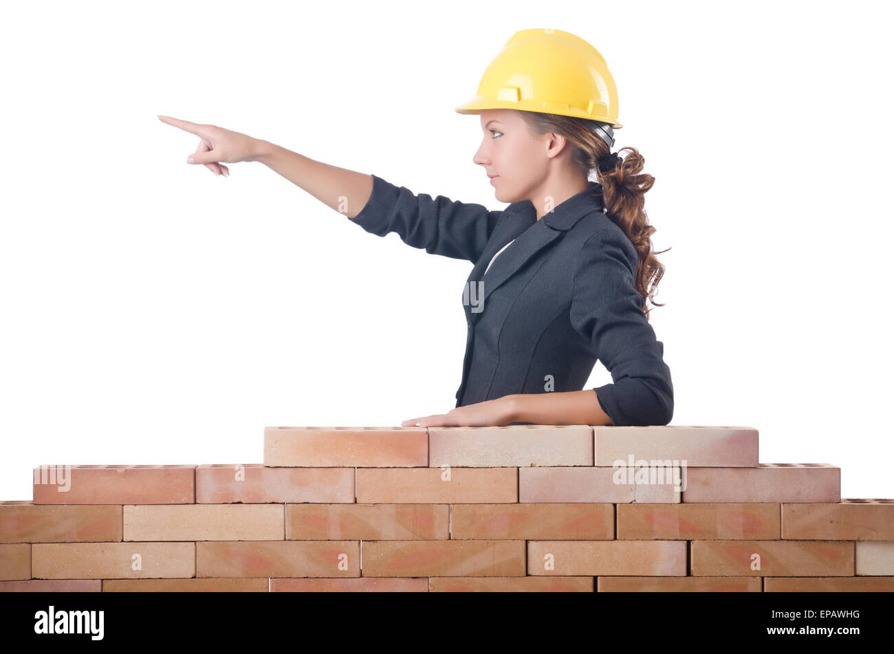 Young female builder near brick wall Stock Photo - Alamy