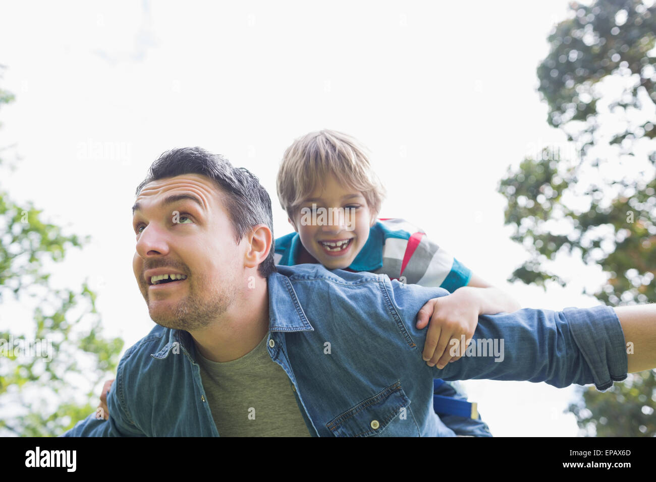 Father carrying cheerful boy on back Stock Photo - Alamy
