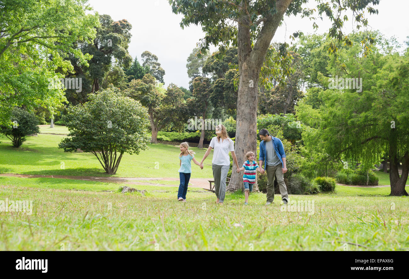 Parents and kids walking in park Stock Photo - Alamy