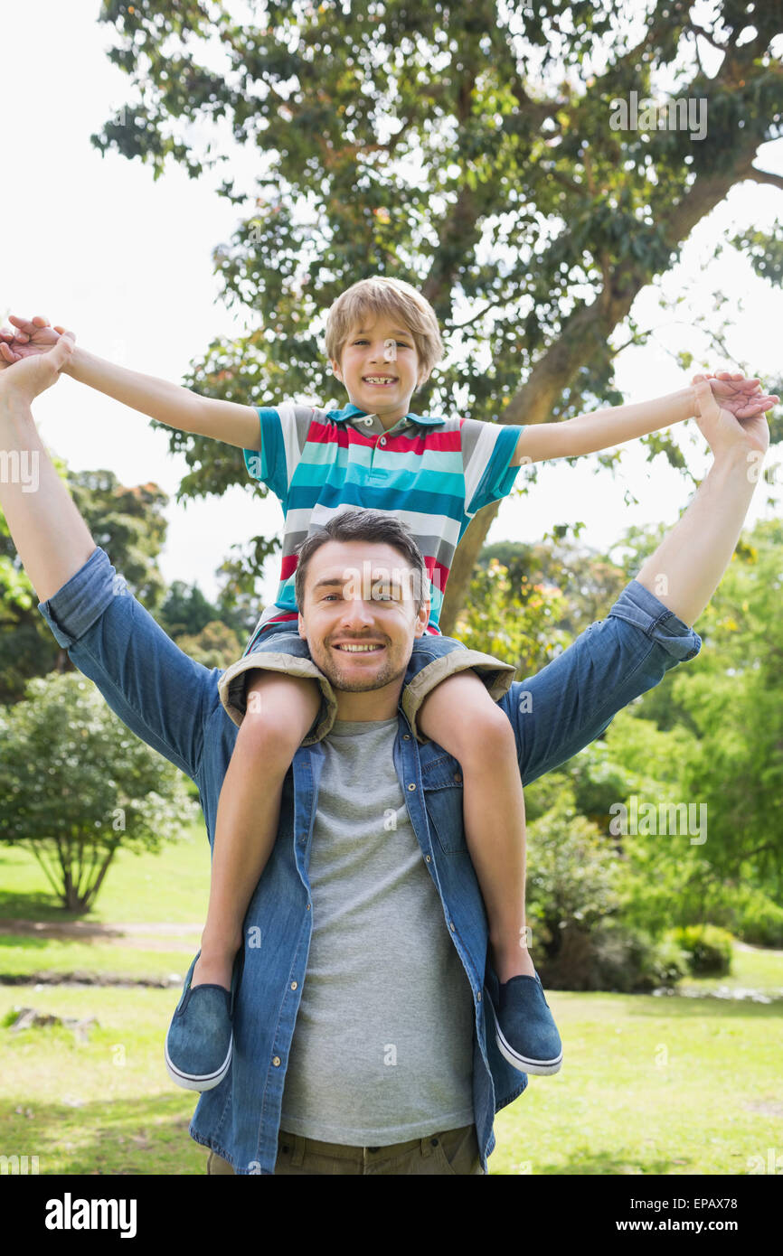 Father carrying boy on shoulders in park Stock Photo - Alamy