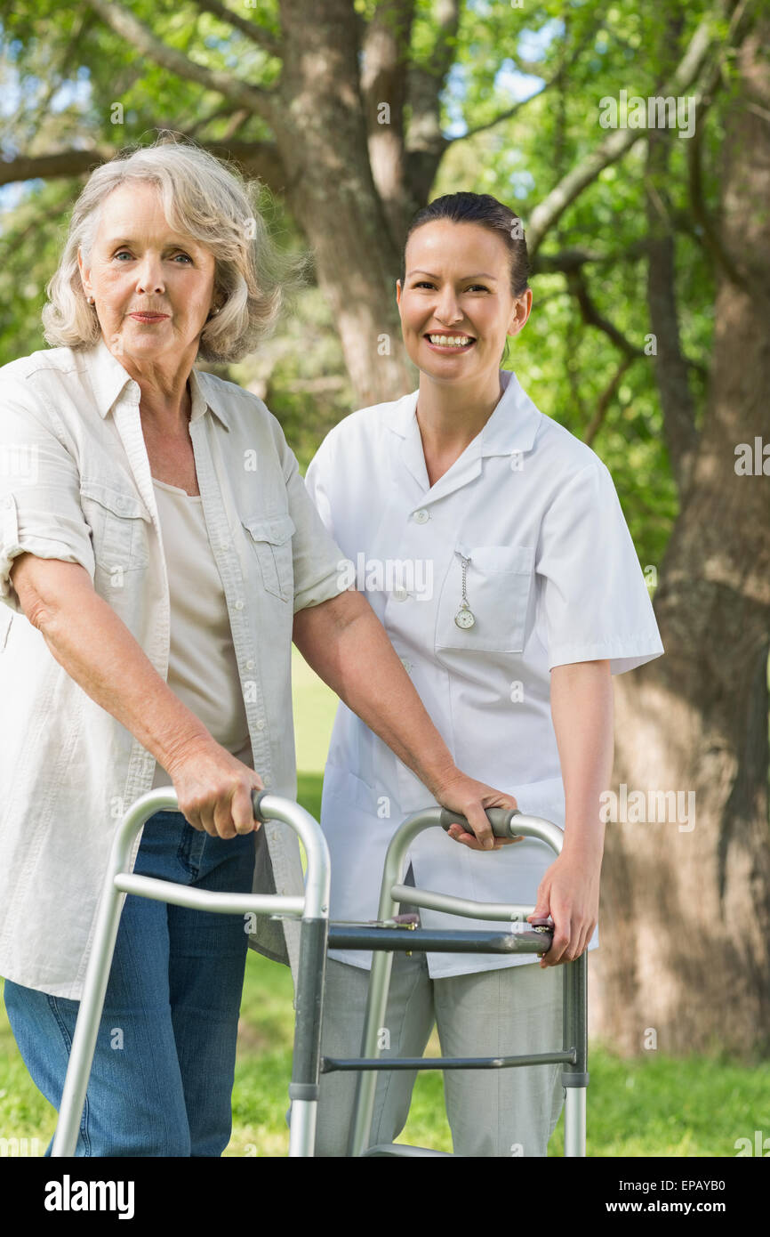 Female assisting mature woman with walker at park Stock Photo - Alamy