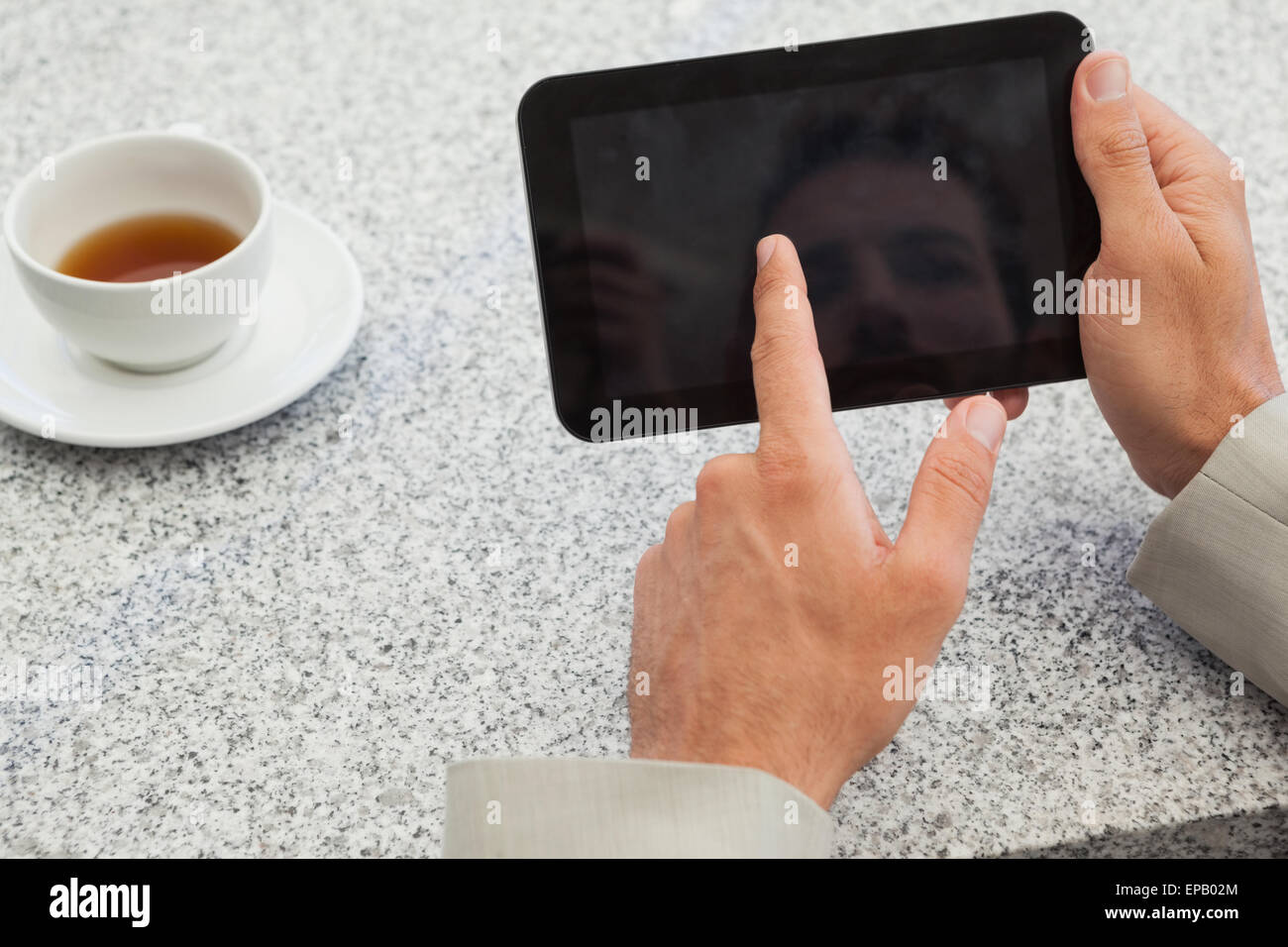 Businessman using small tablet at table Stock Photo - Alamy