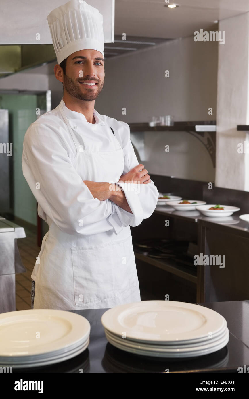 Happy head chef standing with arms crossed behind counter Stock Photo ...