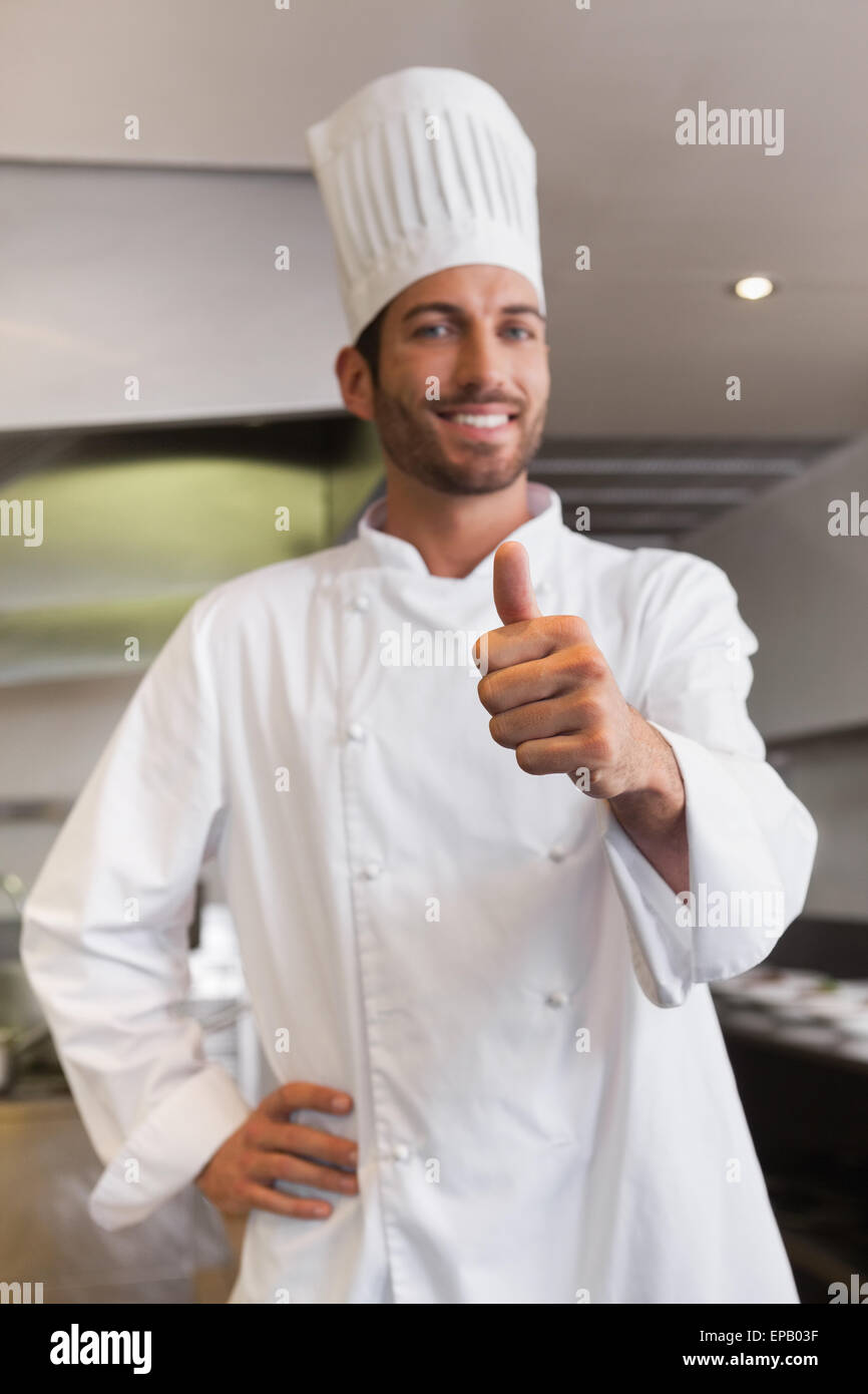 Cheerful young chef looking at camera showing thumb up Stock Photo - Alamy