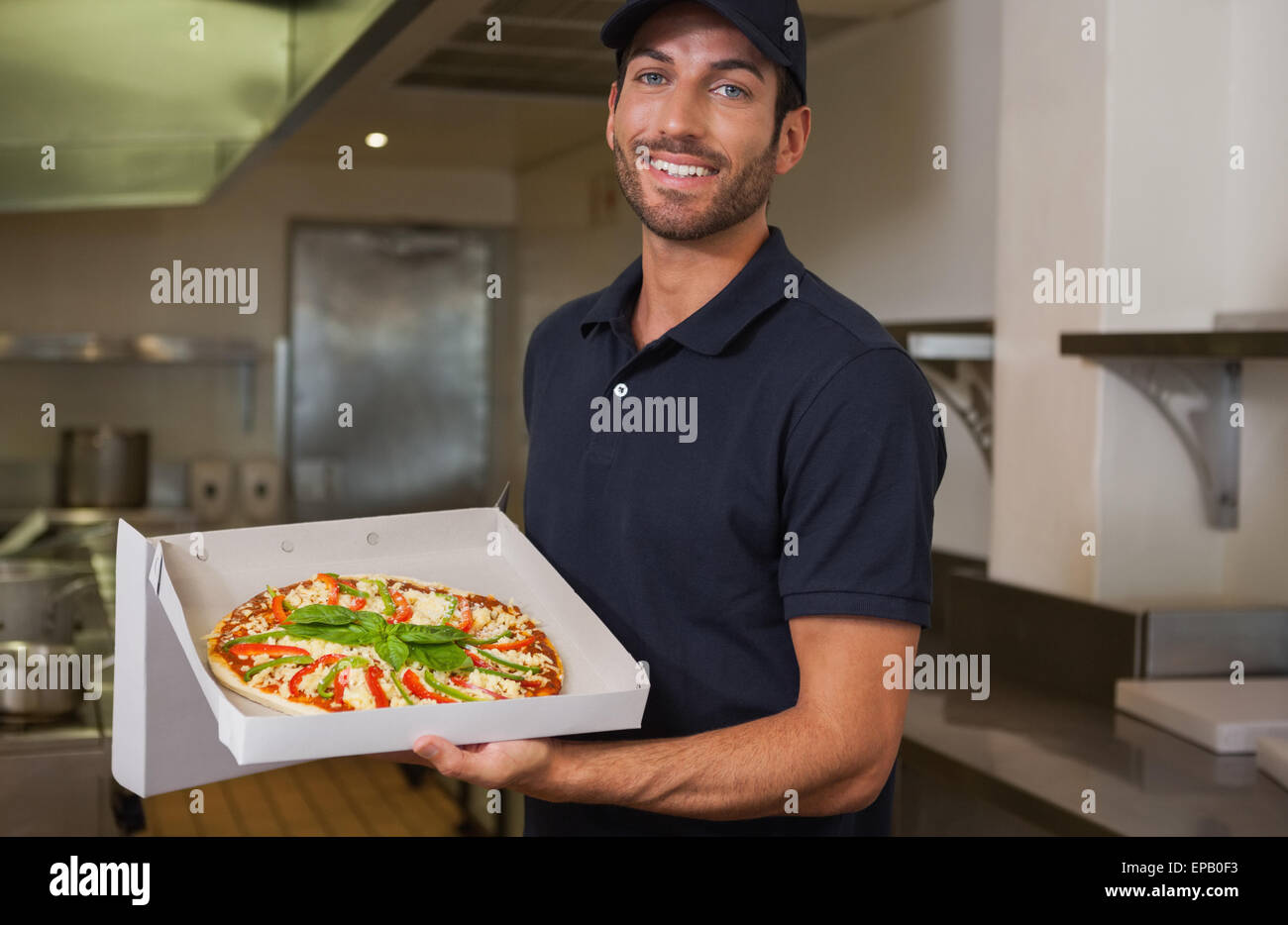 Happy pizza delivery man showing fresh pizza Stock Photo - Alamy