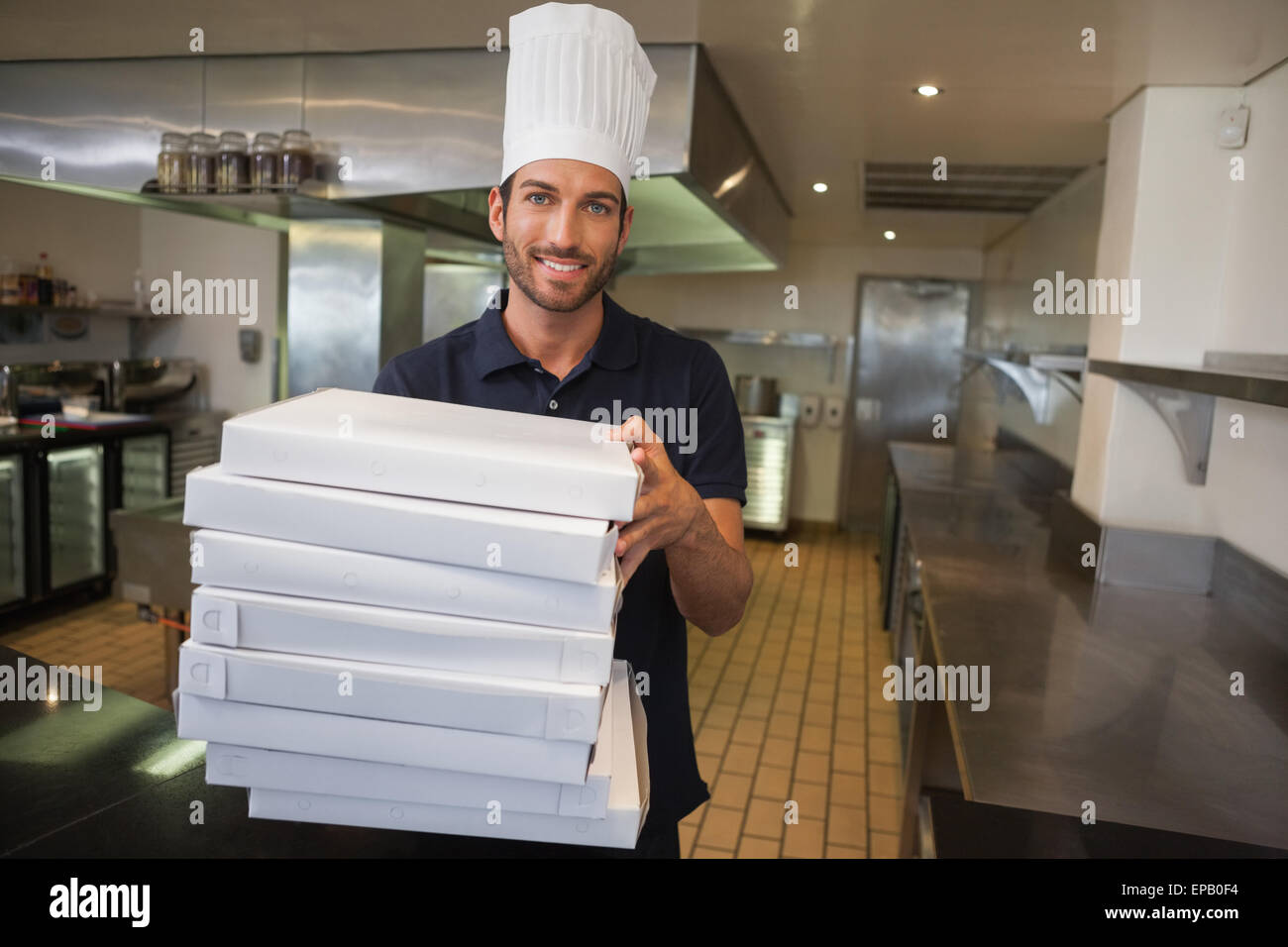 Smiling pizza chef holding stack of pizza boxes Stock Photo - Alamy