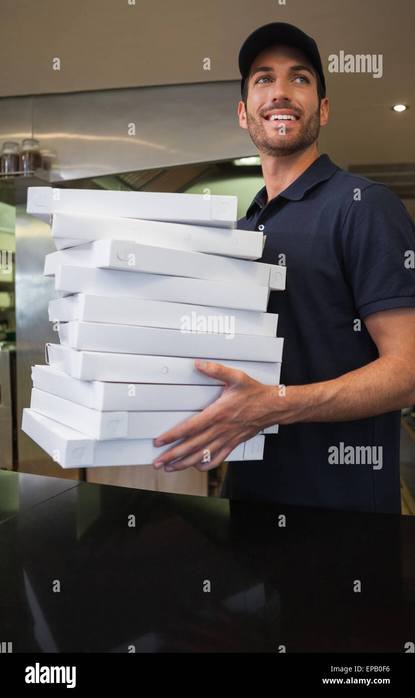 Cheerful pizza delivery man holding many pizza boxes Stock Photo - Alamy