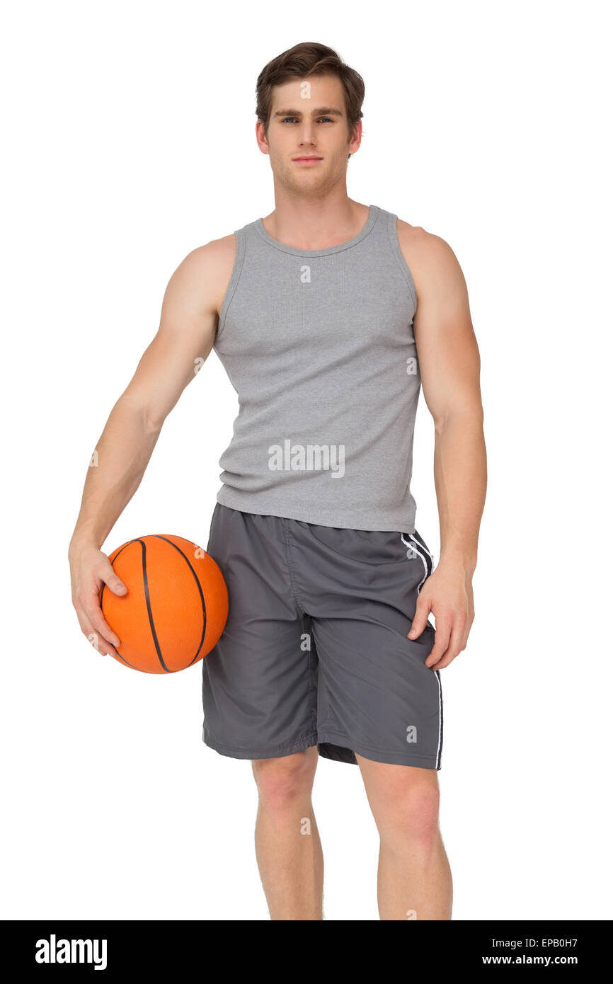 Fit man holding basketball Stock Photo - Alamy