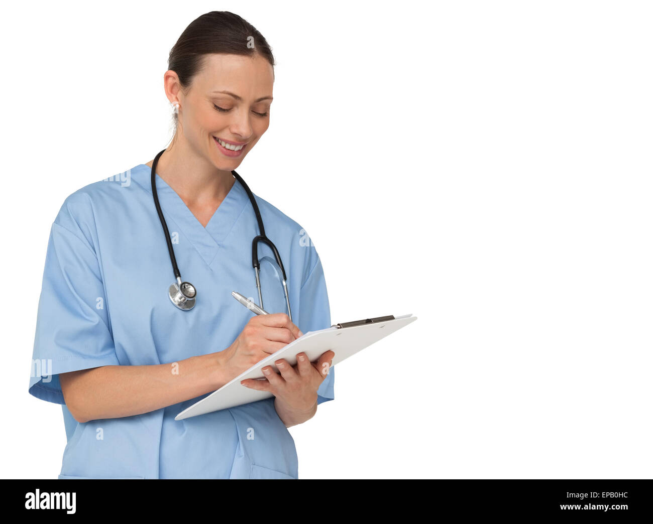 Smiling pretty nurse writing on clipboard Stock Photo - Alamy