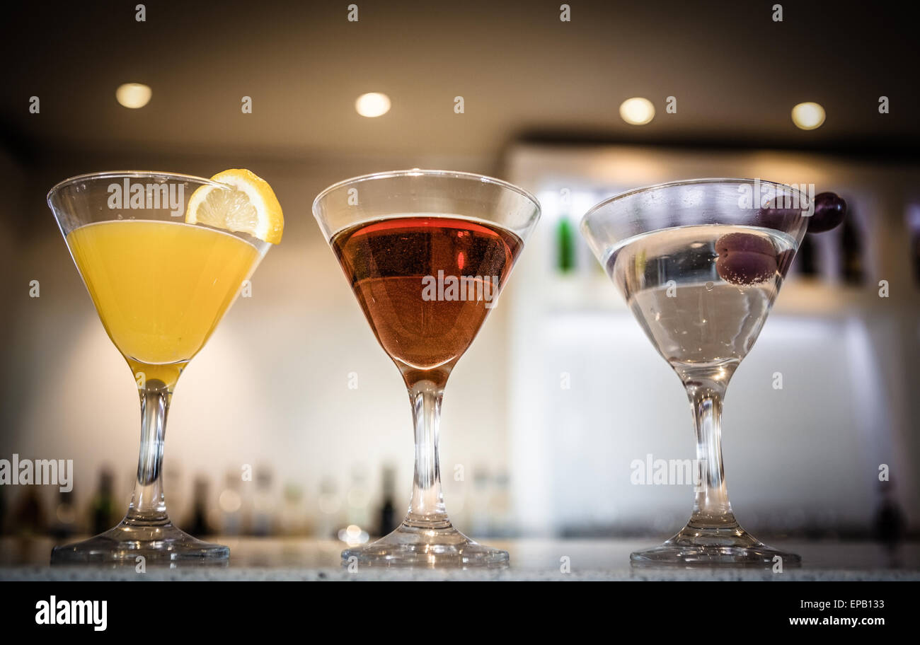 Three cocktails in a row at the bar Stock Photo - Alamy