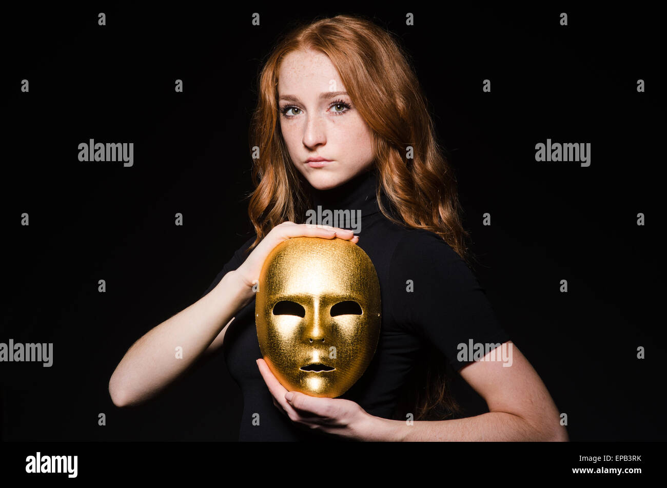 Redhead woman iwith mask in hypocrisy consept against black background ...
