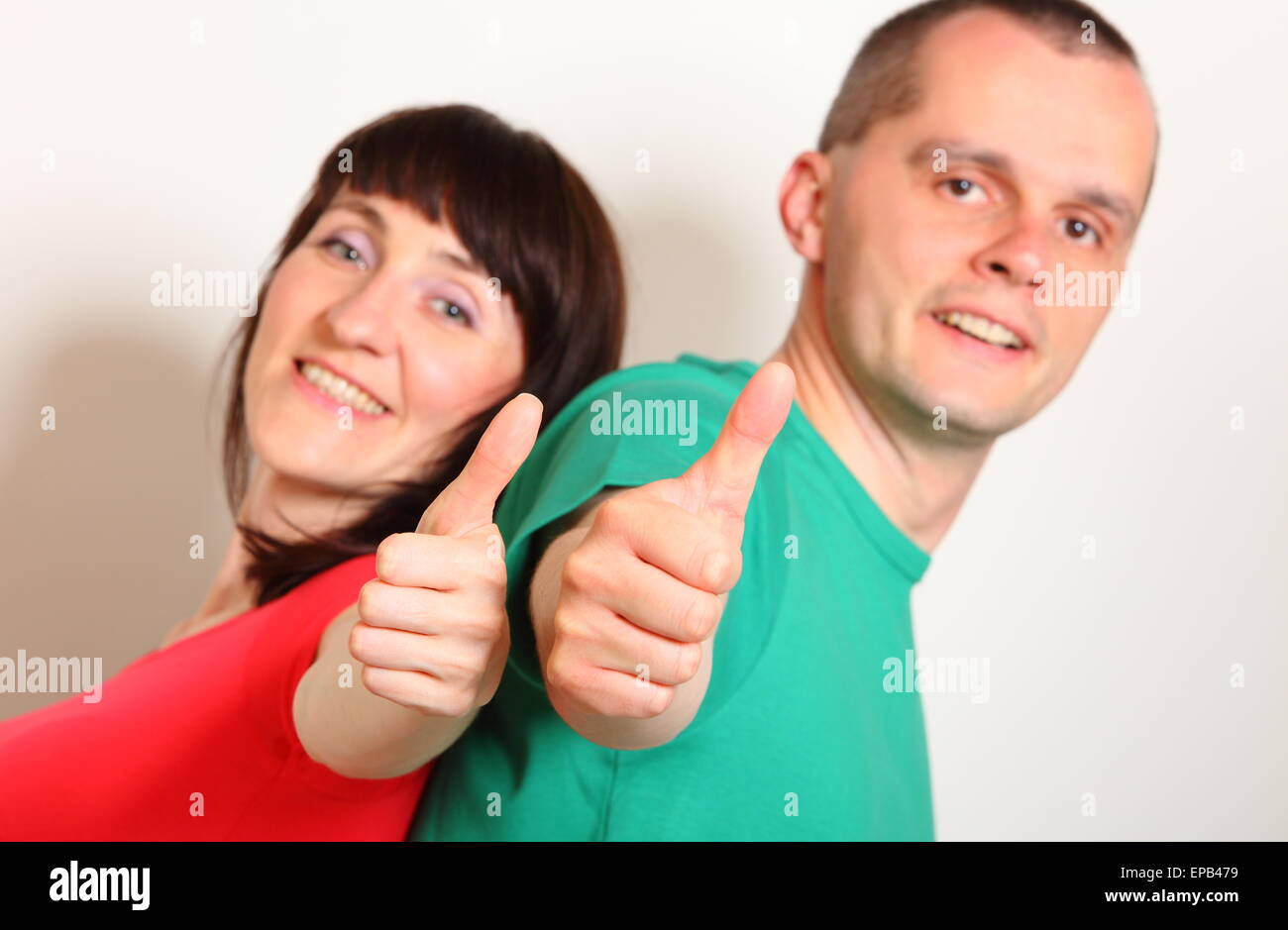 Smiling woman and man showing thumbs up, showing positive emotions ...
