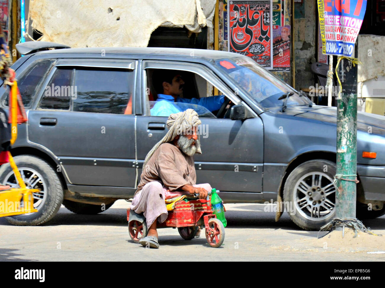 A disable beggar crossing the road while heavy traffic passing through ...