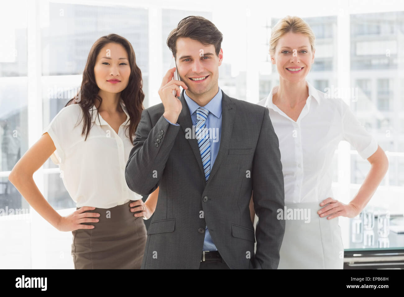 Happy businessman on the phone in front of his team Stock Photo - Alamy