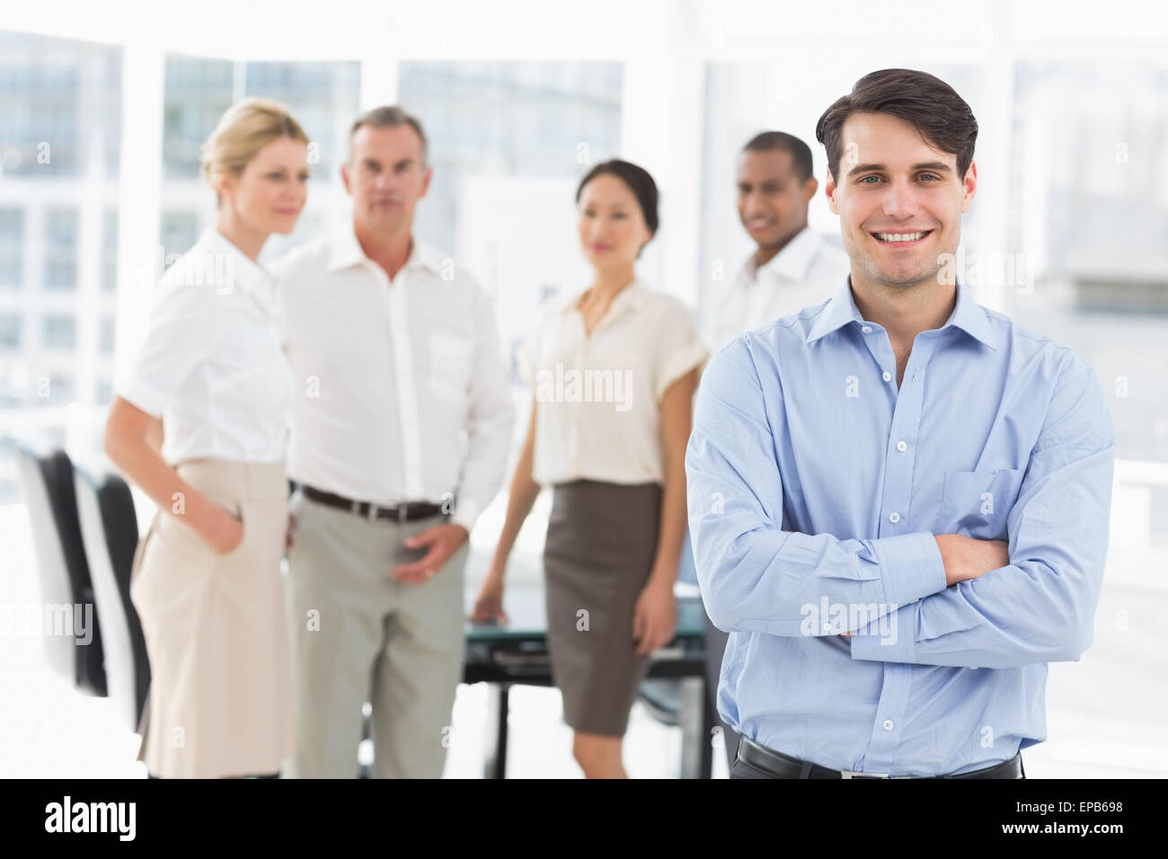 Happy businessman standing with team behind him Stock Photo - Alamy