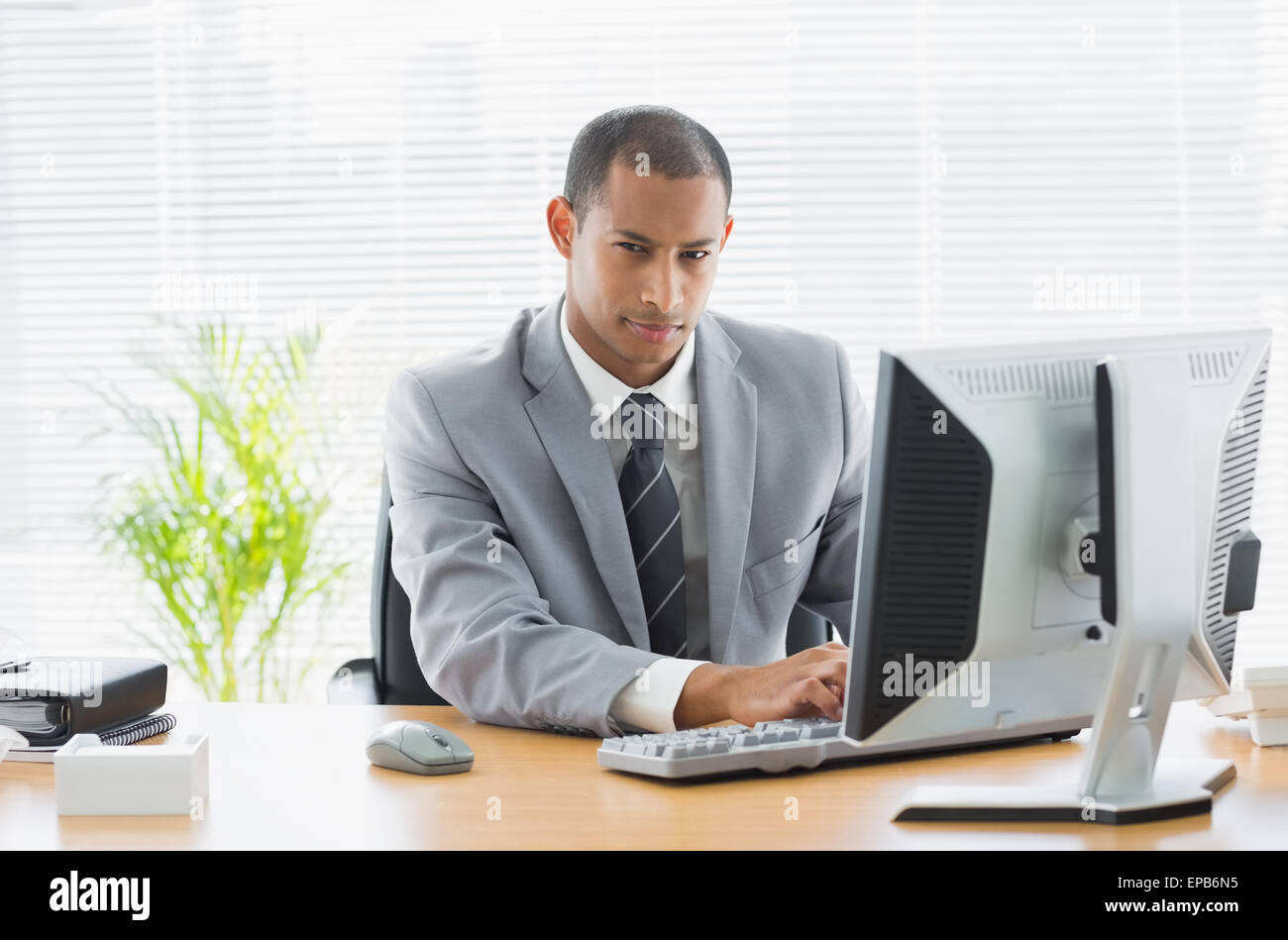 Serious businessman using computer at office Stock Photo - Alamy