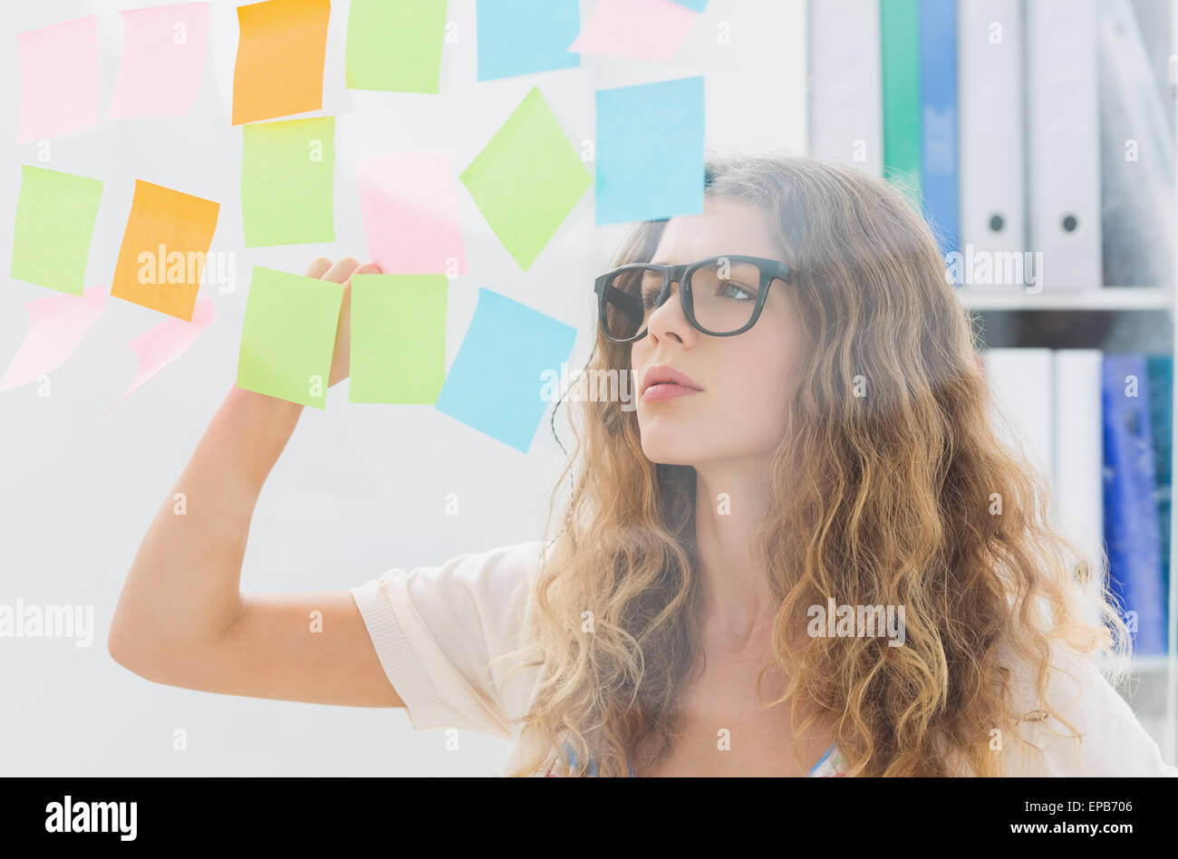 Concentrated artist looking at colorful sticky notes Stock Photo - Alamy