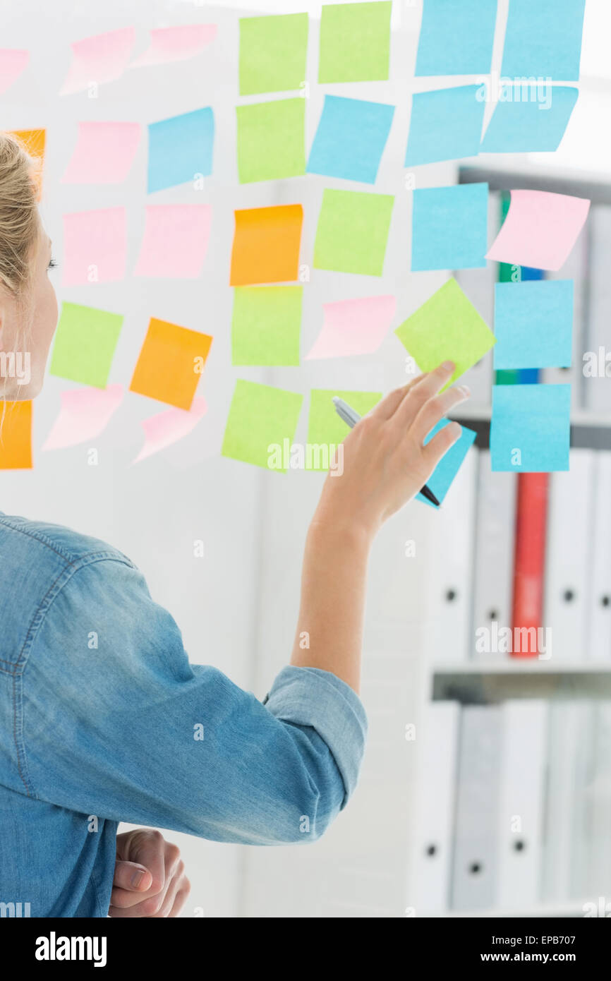 Rear view of a female artist looking at colorful sticky notes Stock ...