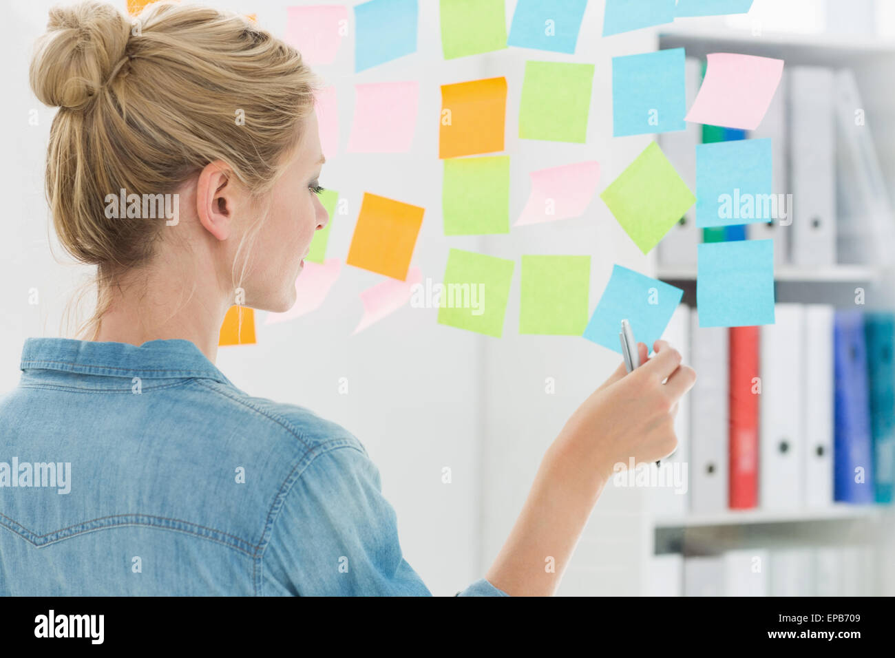 Rear view of a female artist looking at colorful sticky notes Stock ...