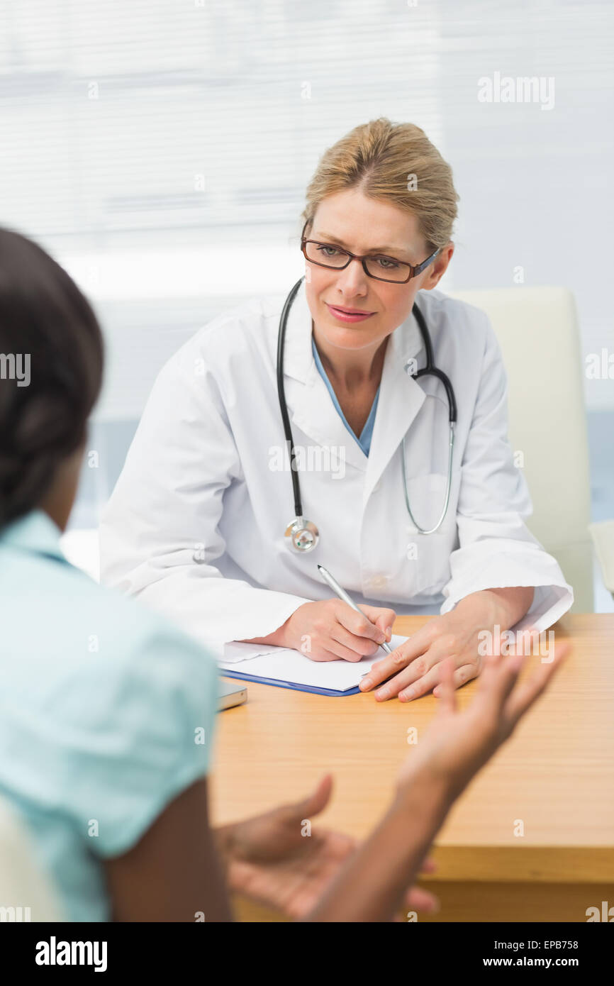 Doctor sitting desk taking notes hi-res stock photography and images ...
