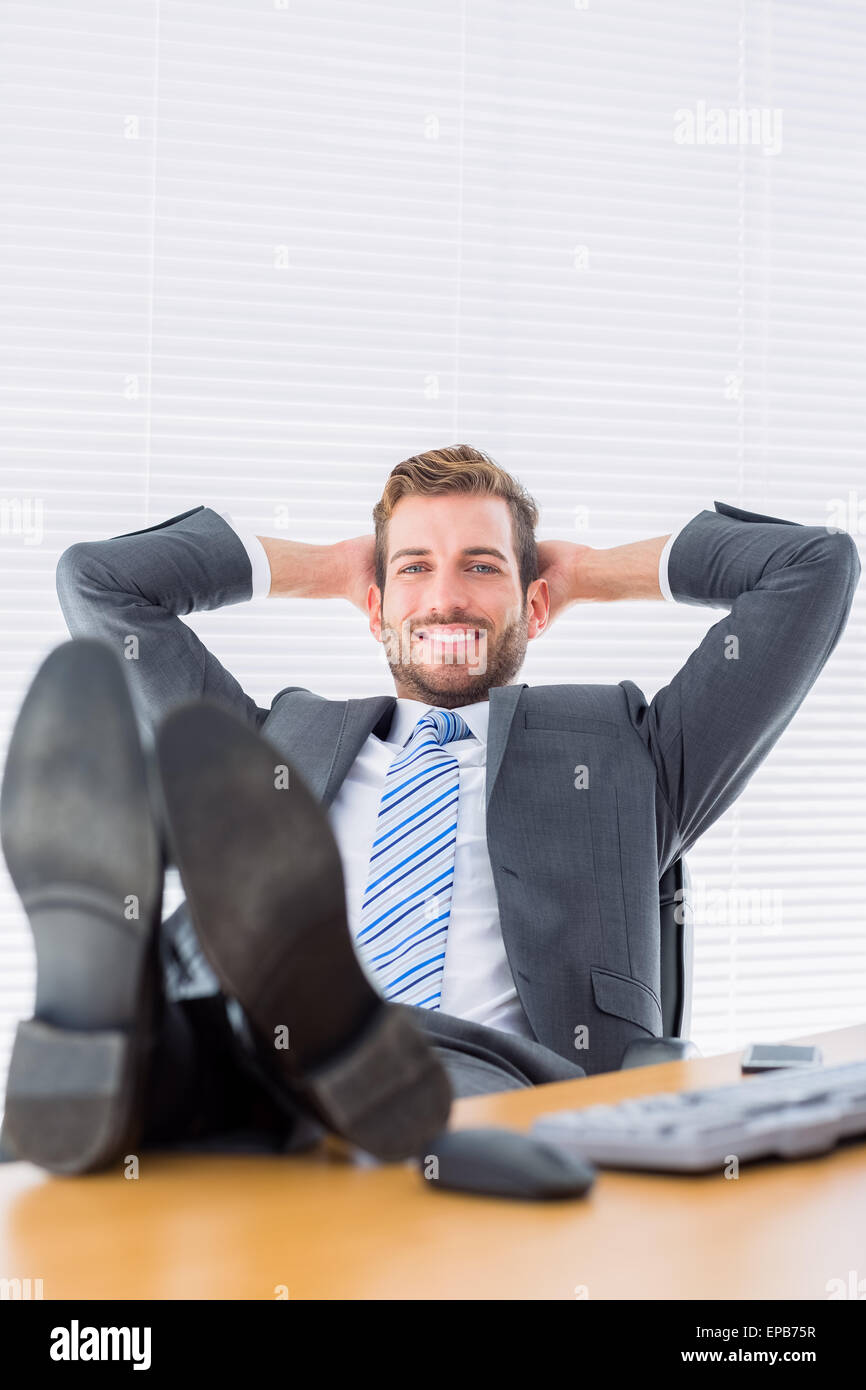 Relaxed businessman sitting with legs on desk Stock Photo - Alamy