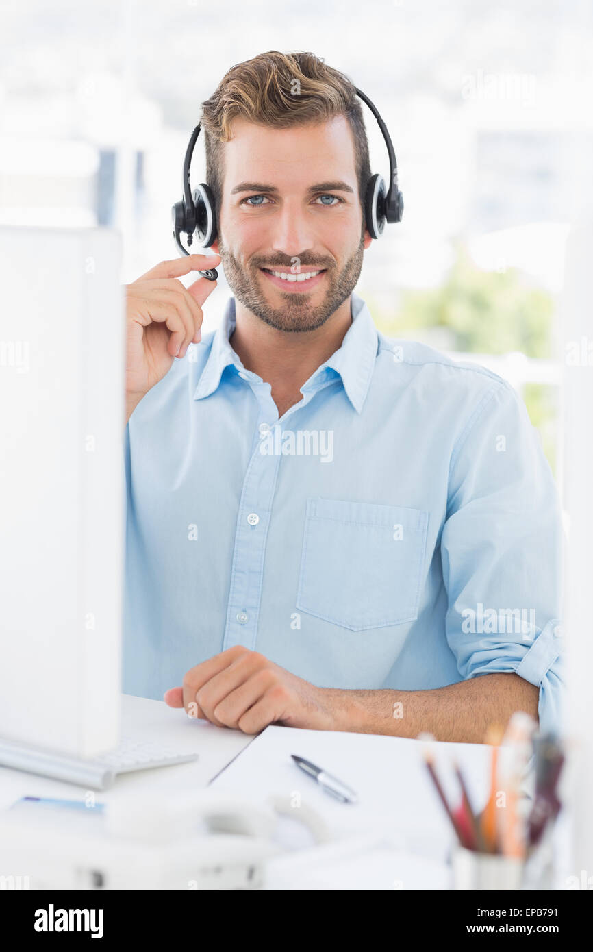 Portrait of a casual young man with headset using computer Stock Photo ...