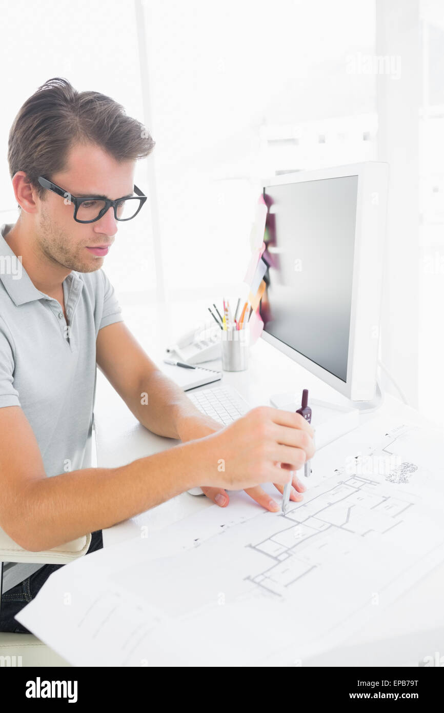 Concentrated man using compass on design Stock Photo - Alamy