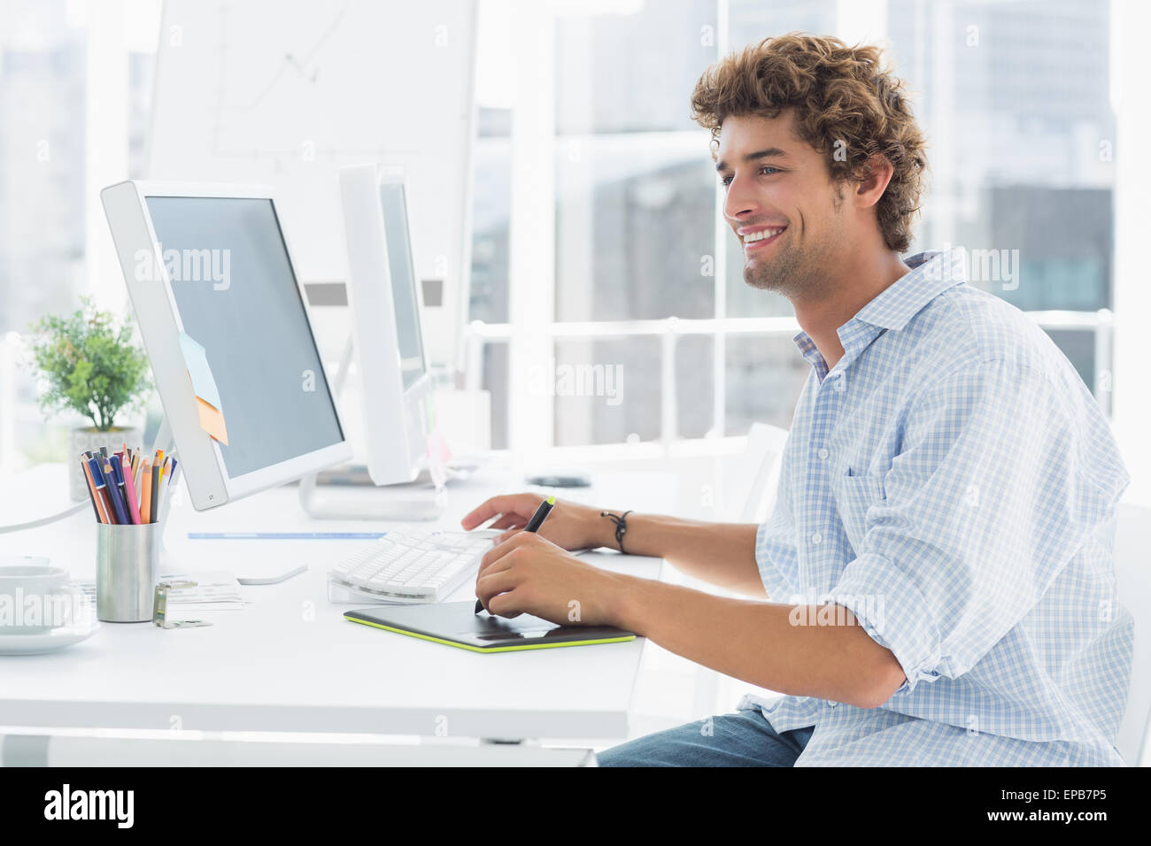 Artist drawing something on graphic tablet with pen Stock Photo - Alamy