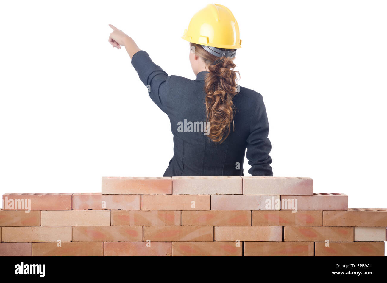 Young female builder near brick wall Stock Photo - Alamy