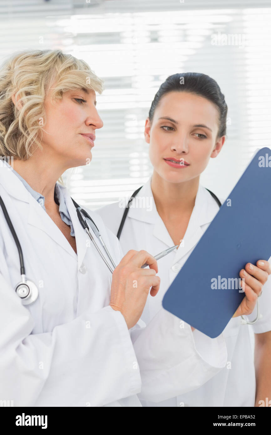 Two female doctors reading medical reports Stock Photo - Alamy