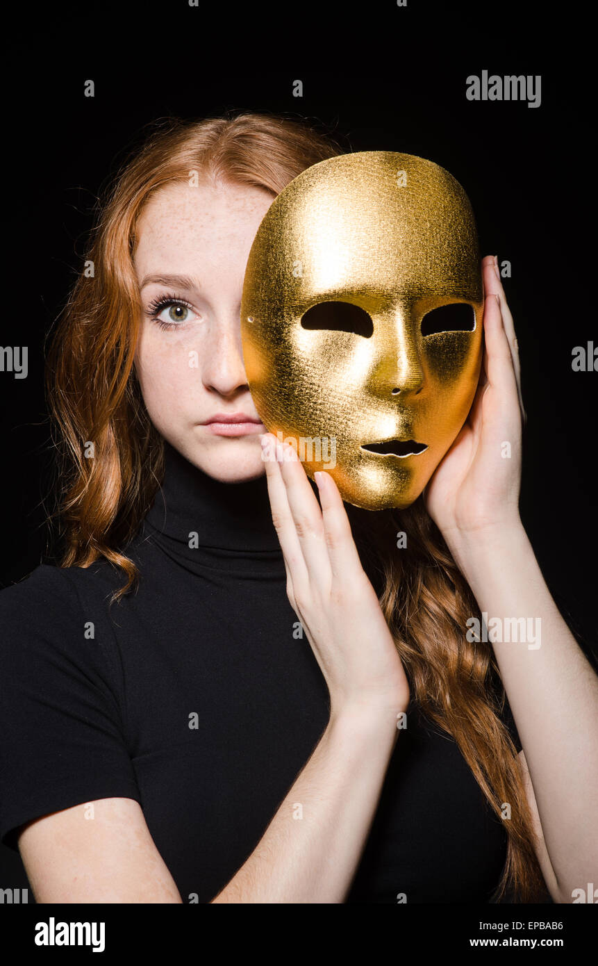 Redhead woman iwith mask in hypocrisy consept against black background ...