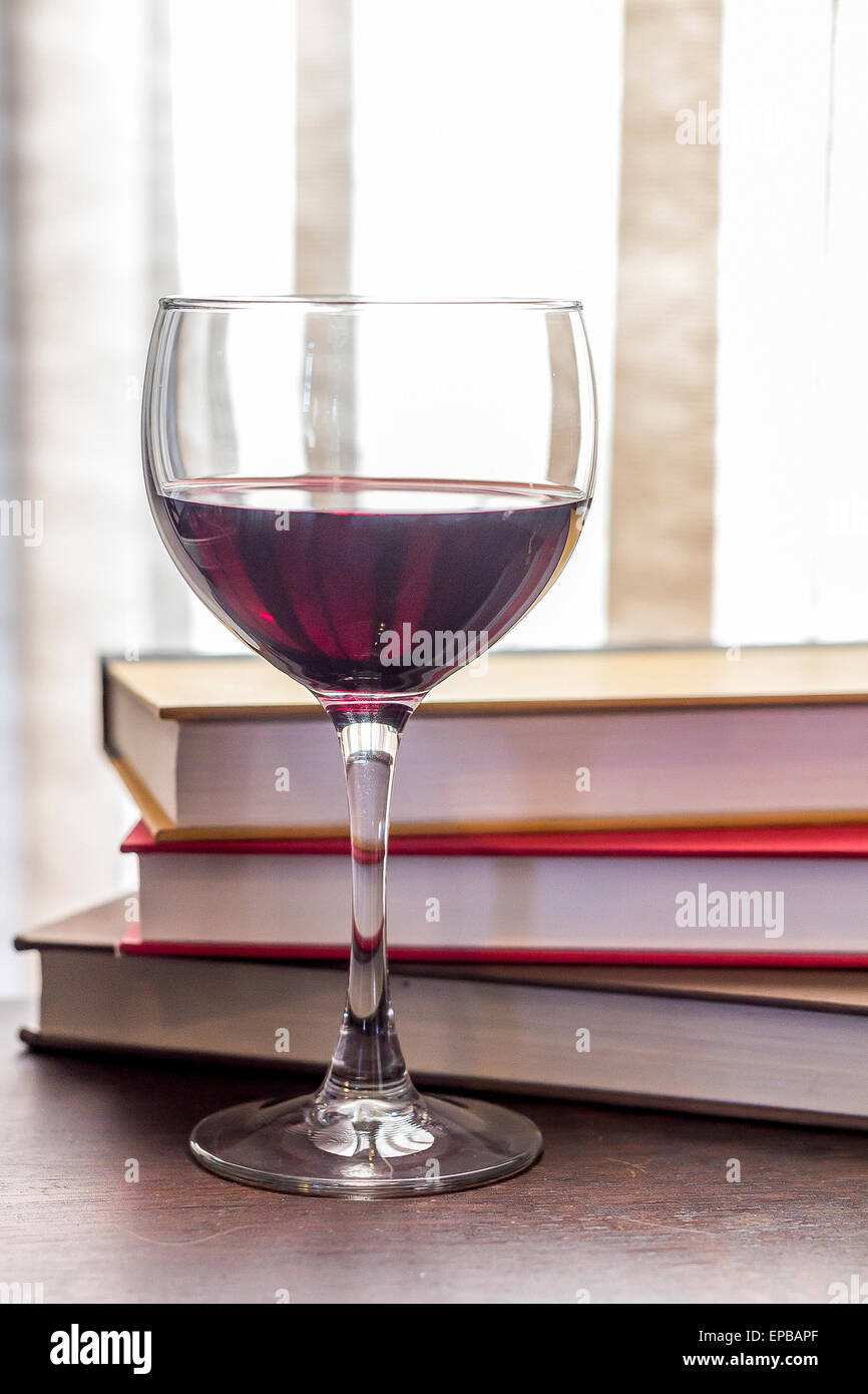 Stack of books with glass of wine in this relaxation themed desk top ...