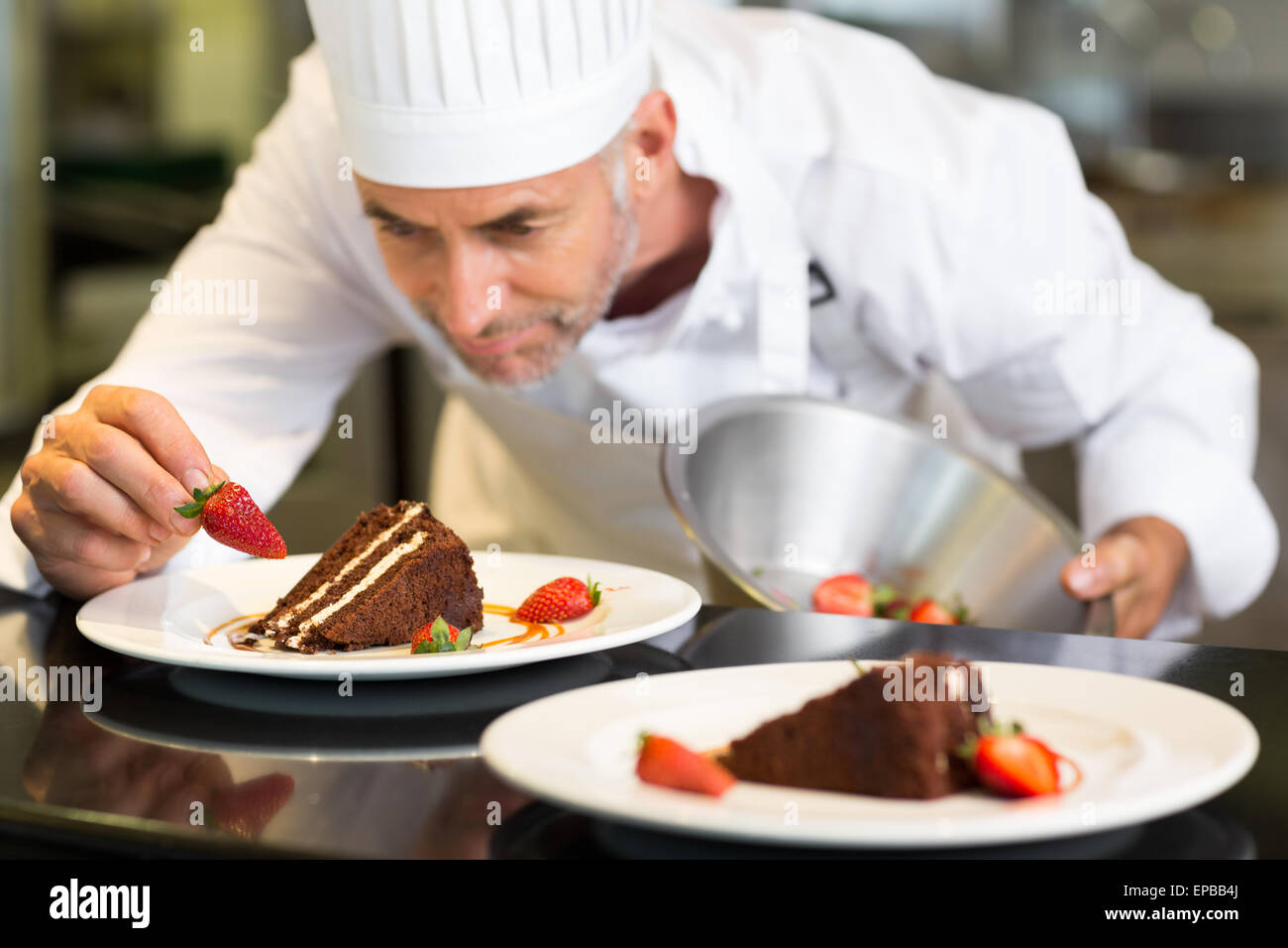 Concentrated male pastry chef decorating dessert Stock Photo - Alamy