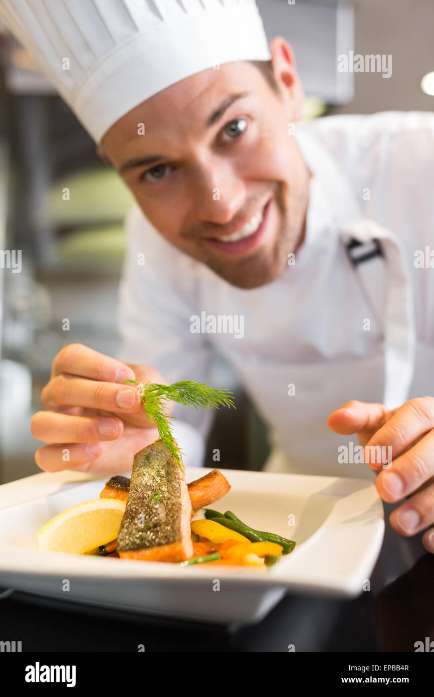 Smiling male chef garnishing food in kitchen Stock Photo - Alamy