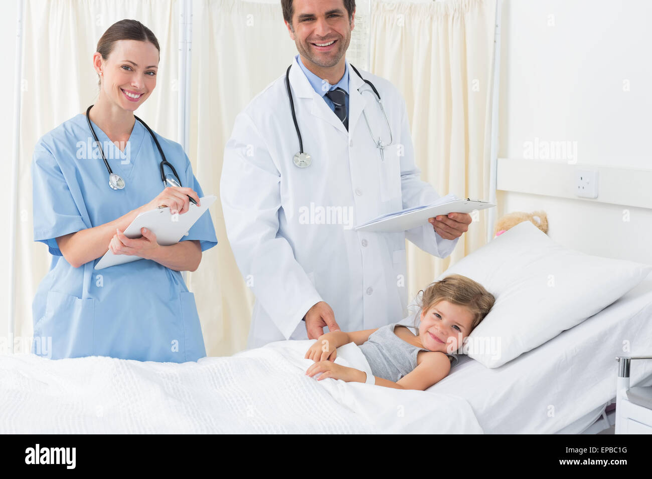 Doctors with sick girl in hospital ward Stock Photo - Alamy