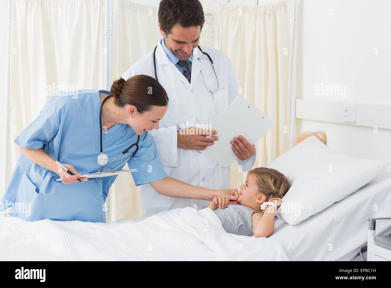 Doctors examining sick girl Stock Photo - Alamy