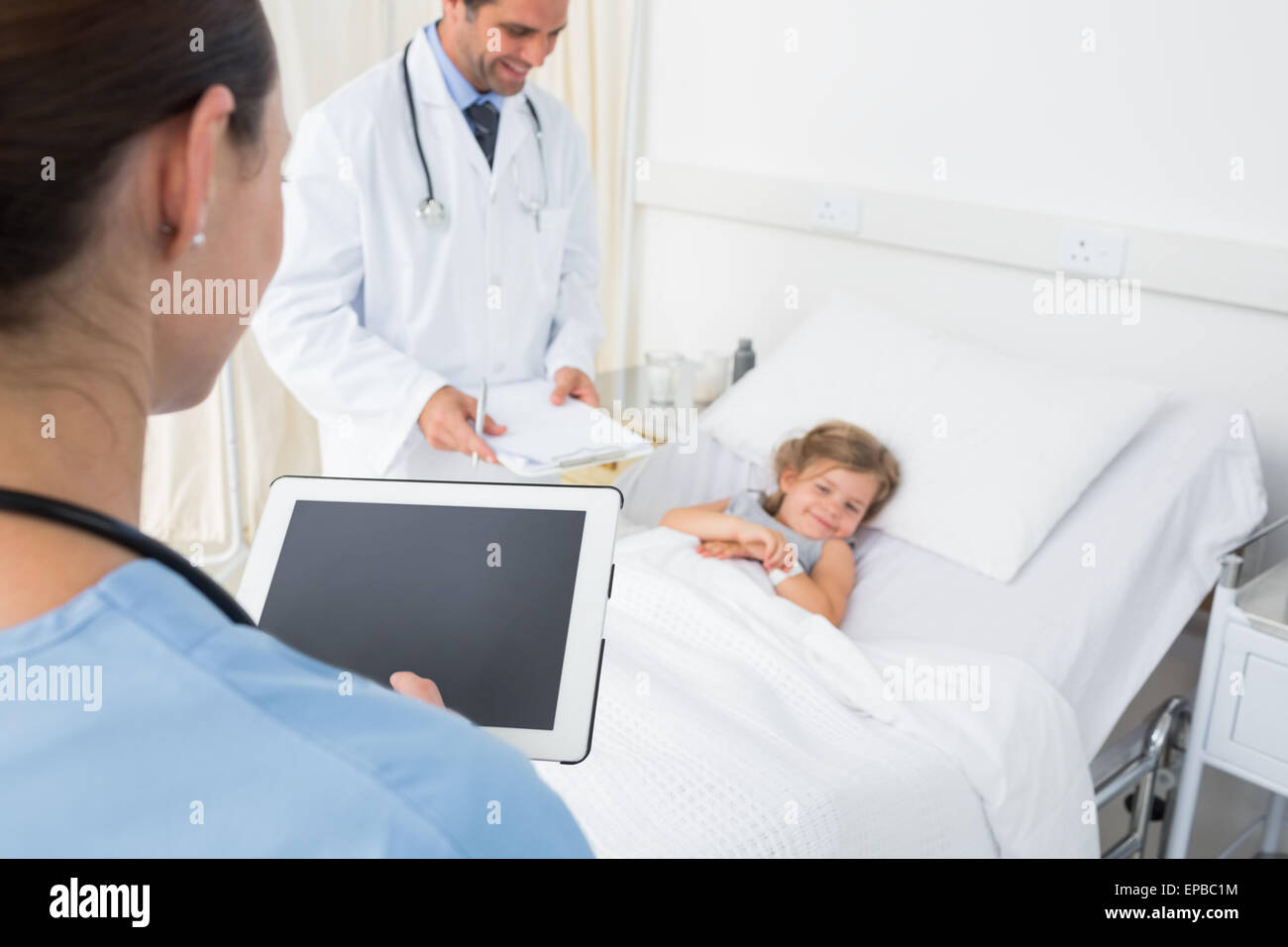 Doctors attending sick girl Stock Photo - Alamy