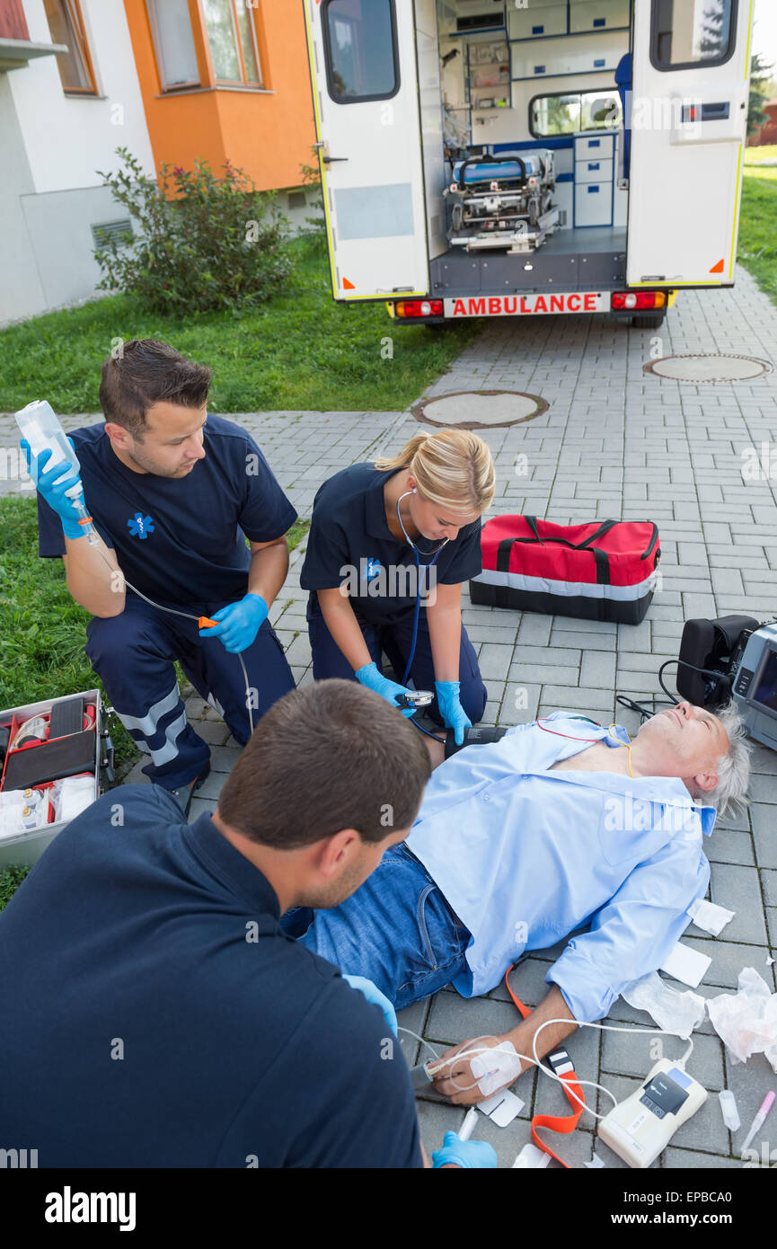Paramedics treating injured man on street Stock Photo - Alamy