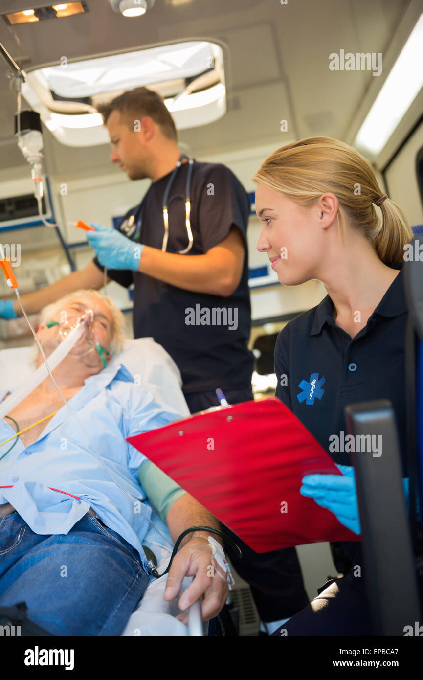 Paramedics examining injured patient in ambulance Stock Photo - Alamy