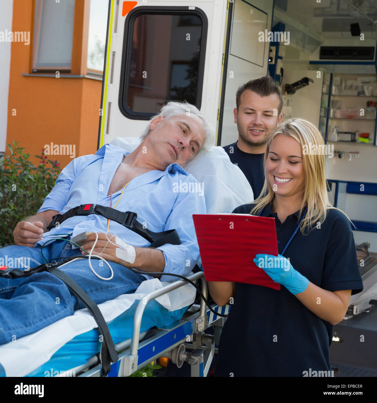 Emergency team treating patient on stretcher Stock Photo - Alamy