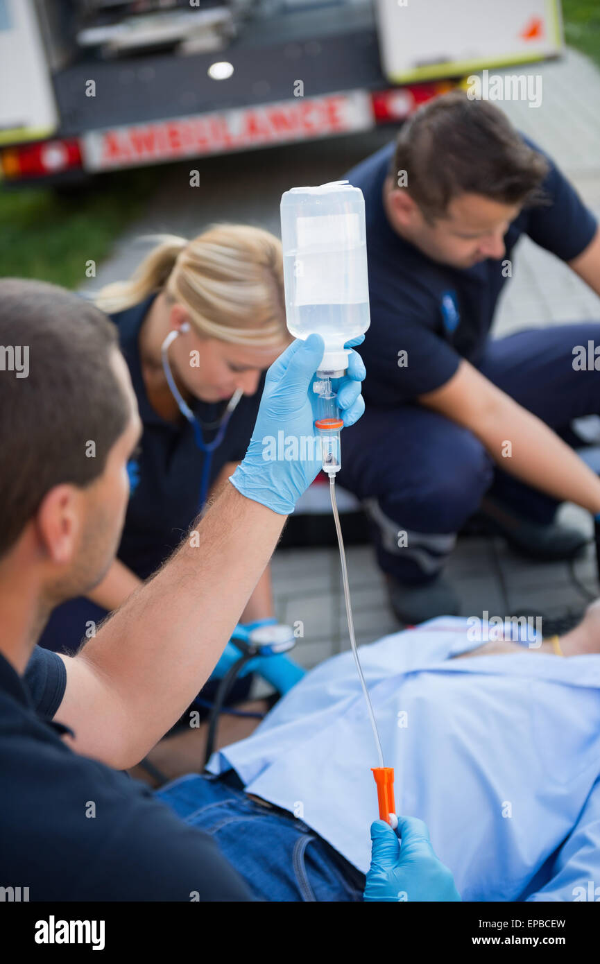Paramedic team preparing drip for injured patient Stock Photo - Alamy