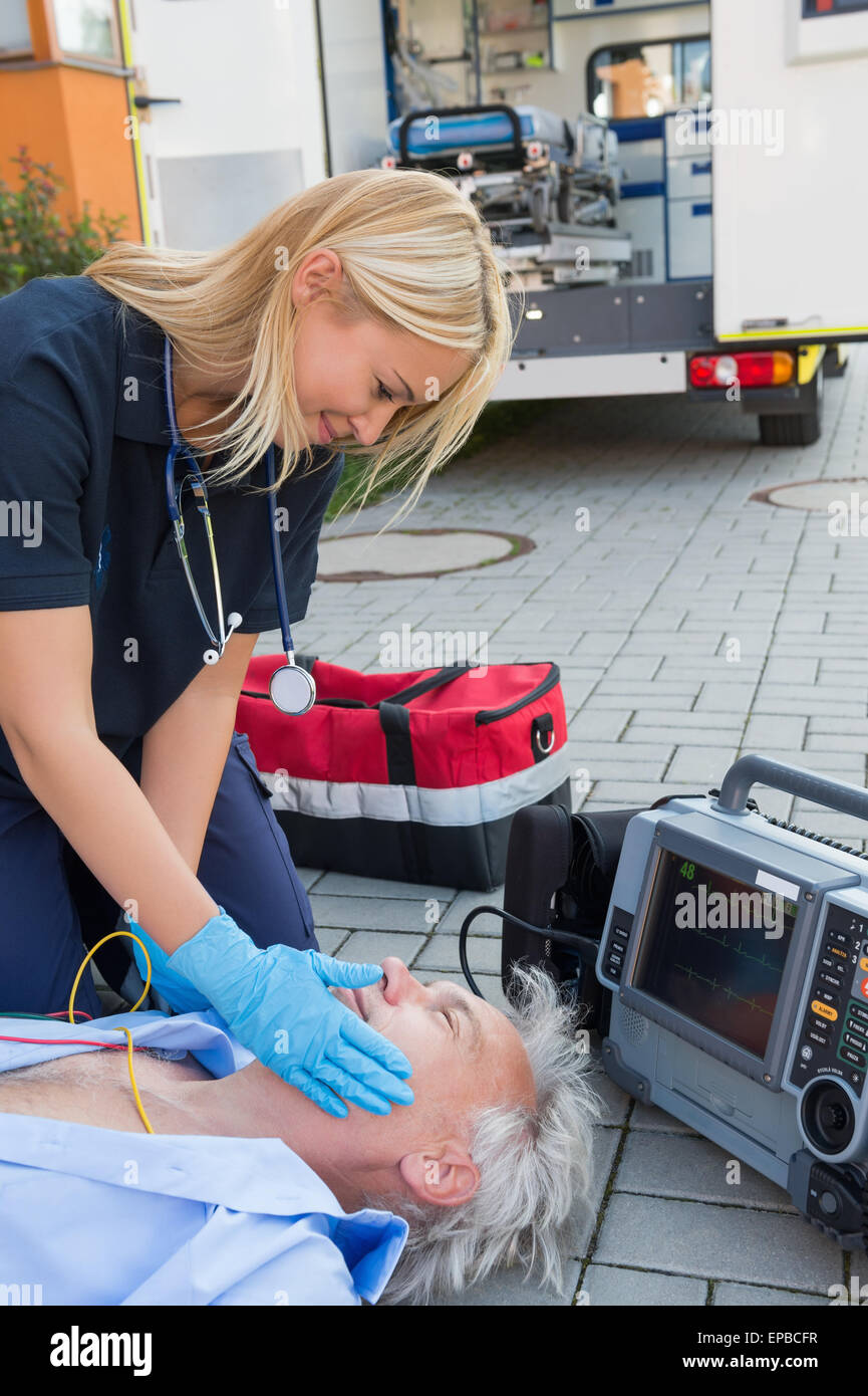 Paramedic helping injured patient on street Stock Photo - Alamy